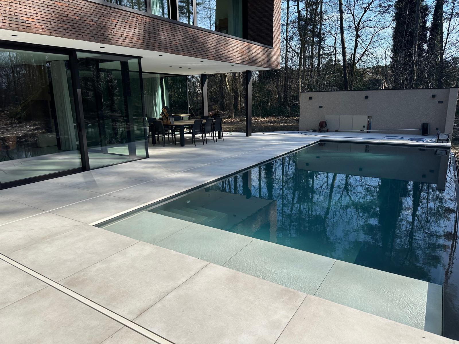 Terras rond zwembad naast villa Concrete House - Technicel